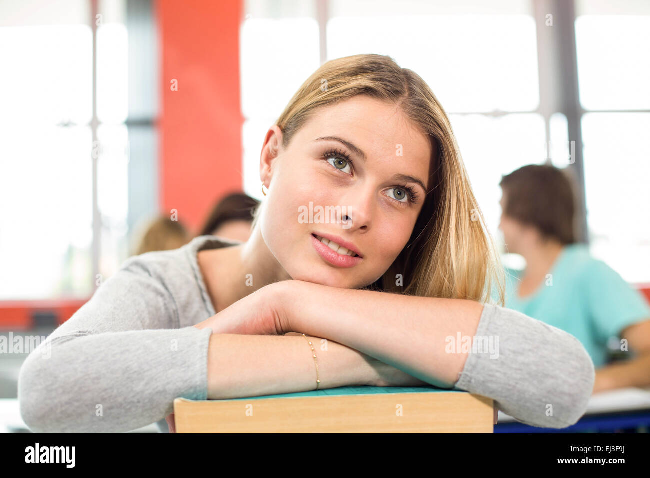 Thoughtful student with books in classroom Stock Photo - Alamy