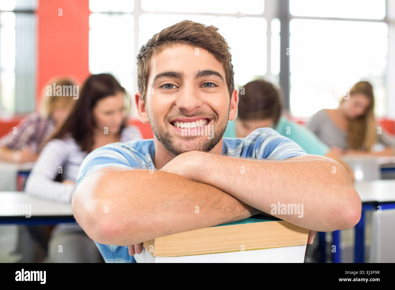 Smiling male student in classroom Stock Photo - Alamy