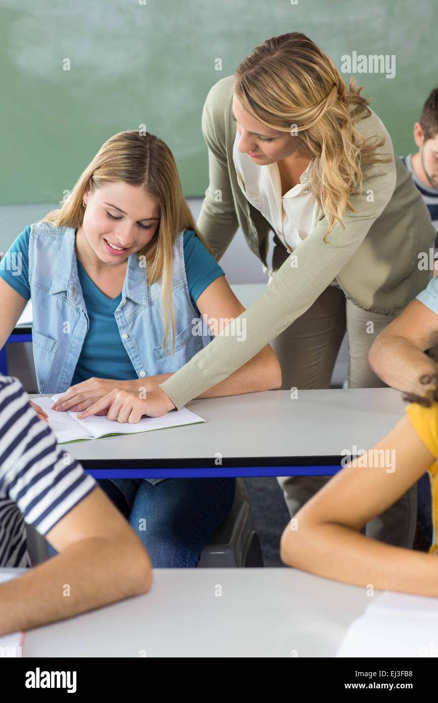 Teacher helping student in class Stock Photo - Alamy