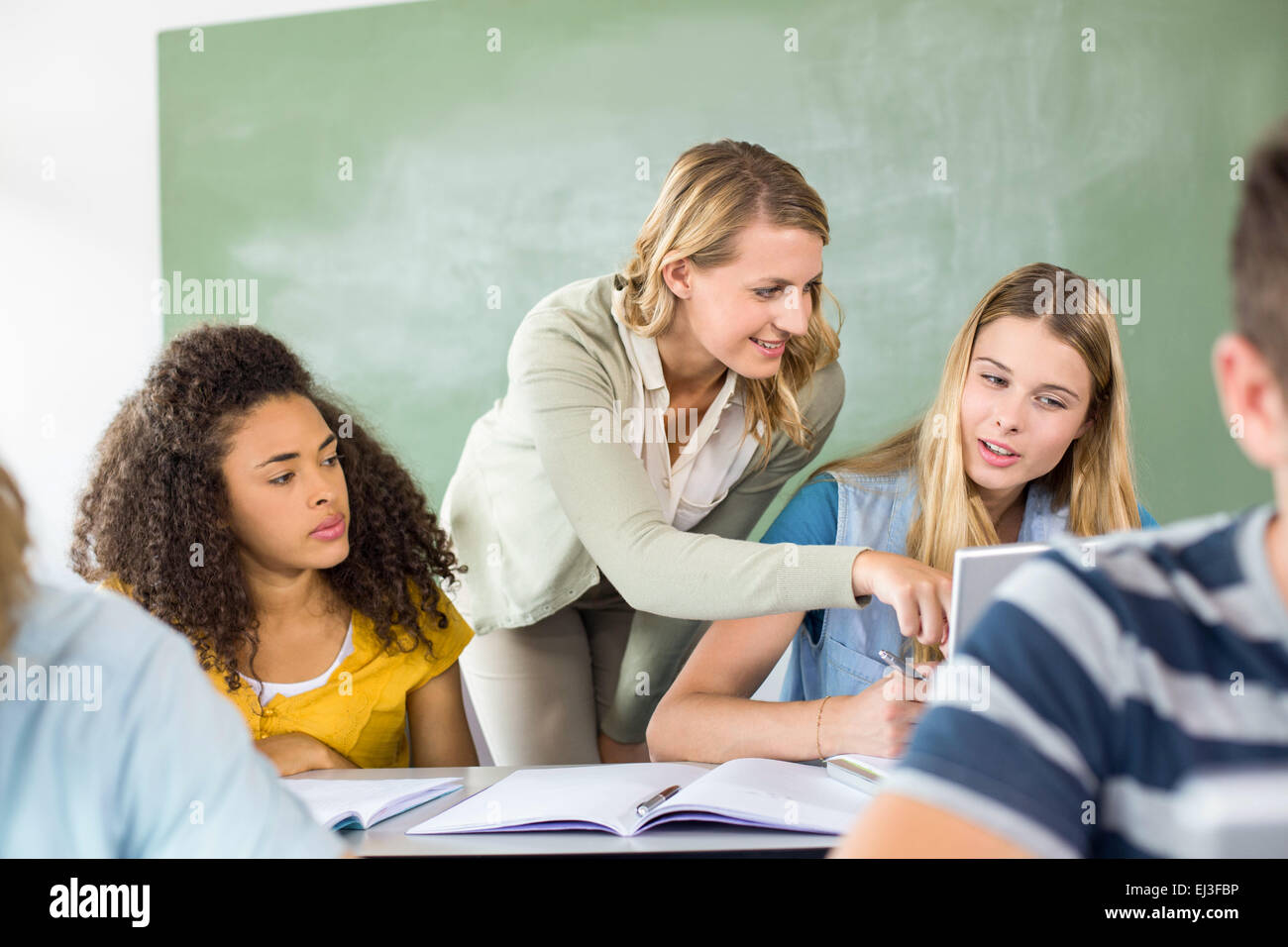 Teacher helping student in class Stock Photo - Alamy