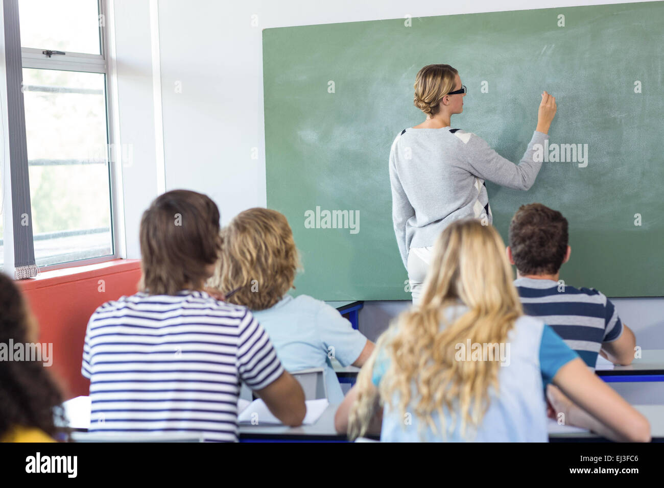 Teacher teaching students in class Stock Photo - Alamy
