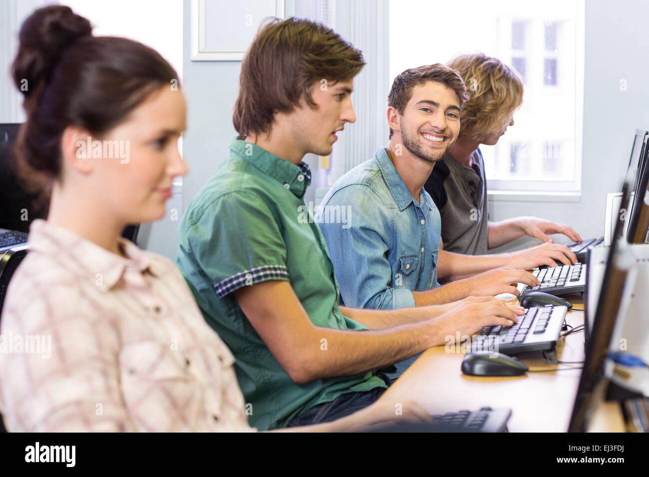 Student smiling at camera in computer class Stock Photo - Alamy