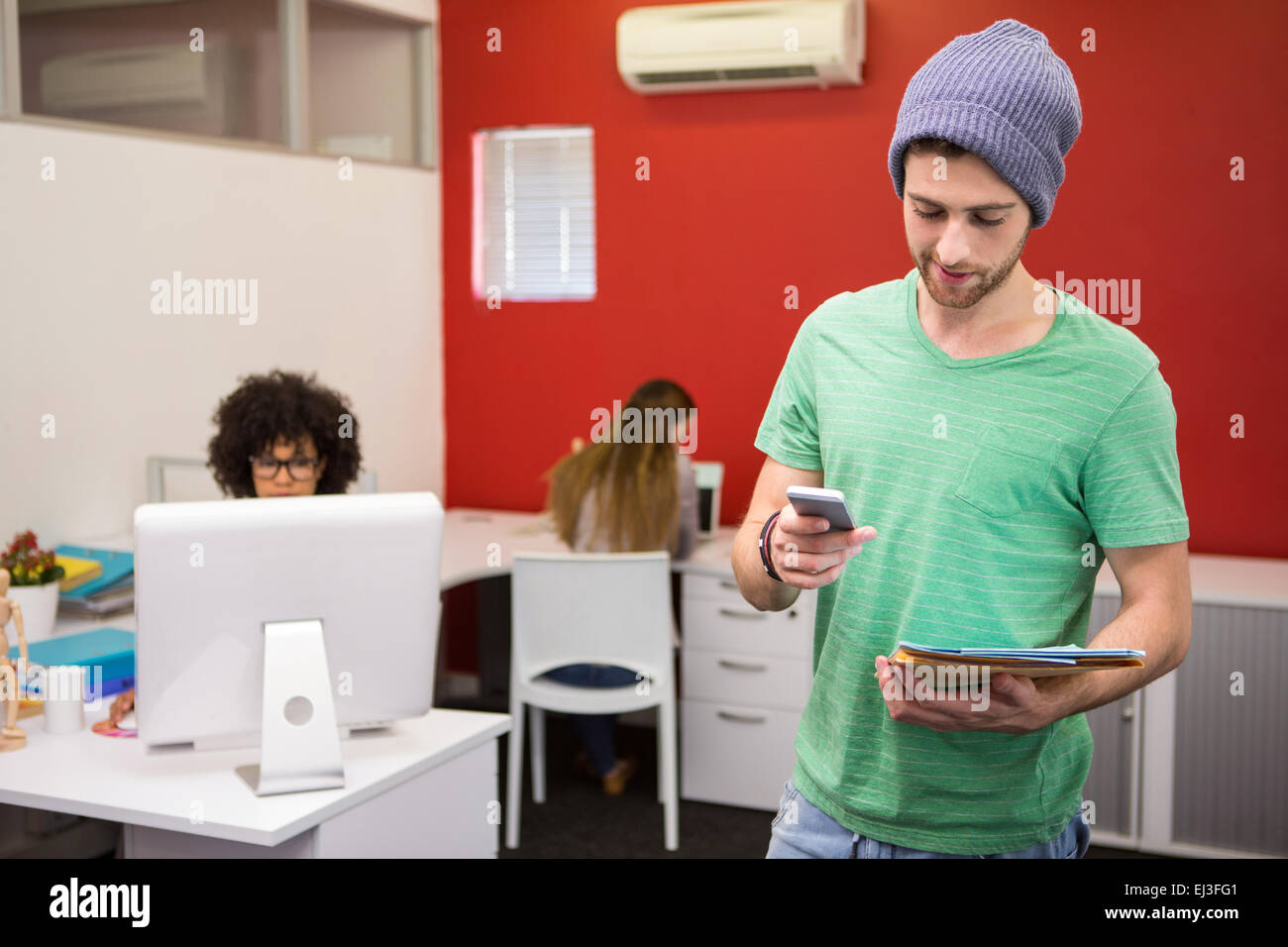 Casual businessman text messaging in office Stock Photo - Alamy