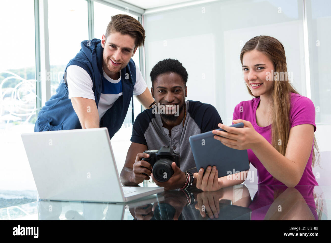 Creative young business team looking at digital tablet Stock Photo - Alamy