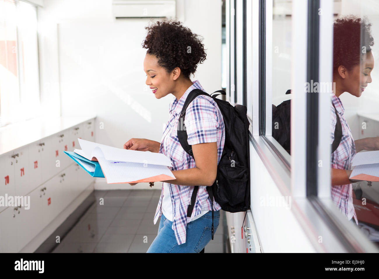 Casual young woman reading folder in office Stock Photo - Alamy