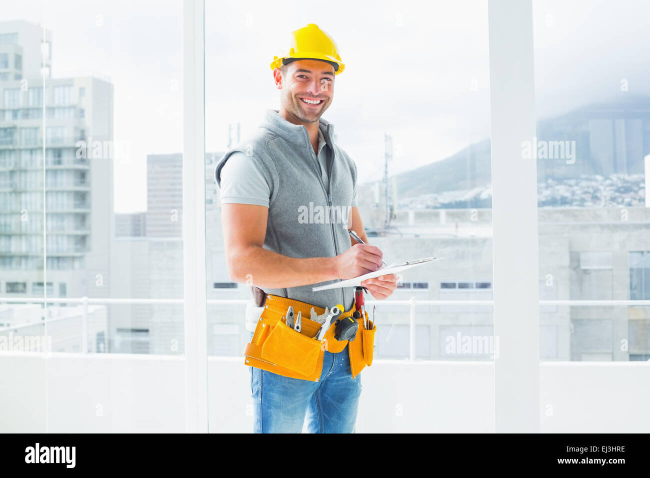 Manual worker writing on clipboard in building Stock Photo - Alamy