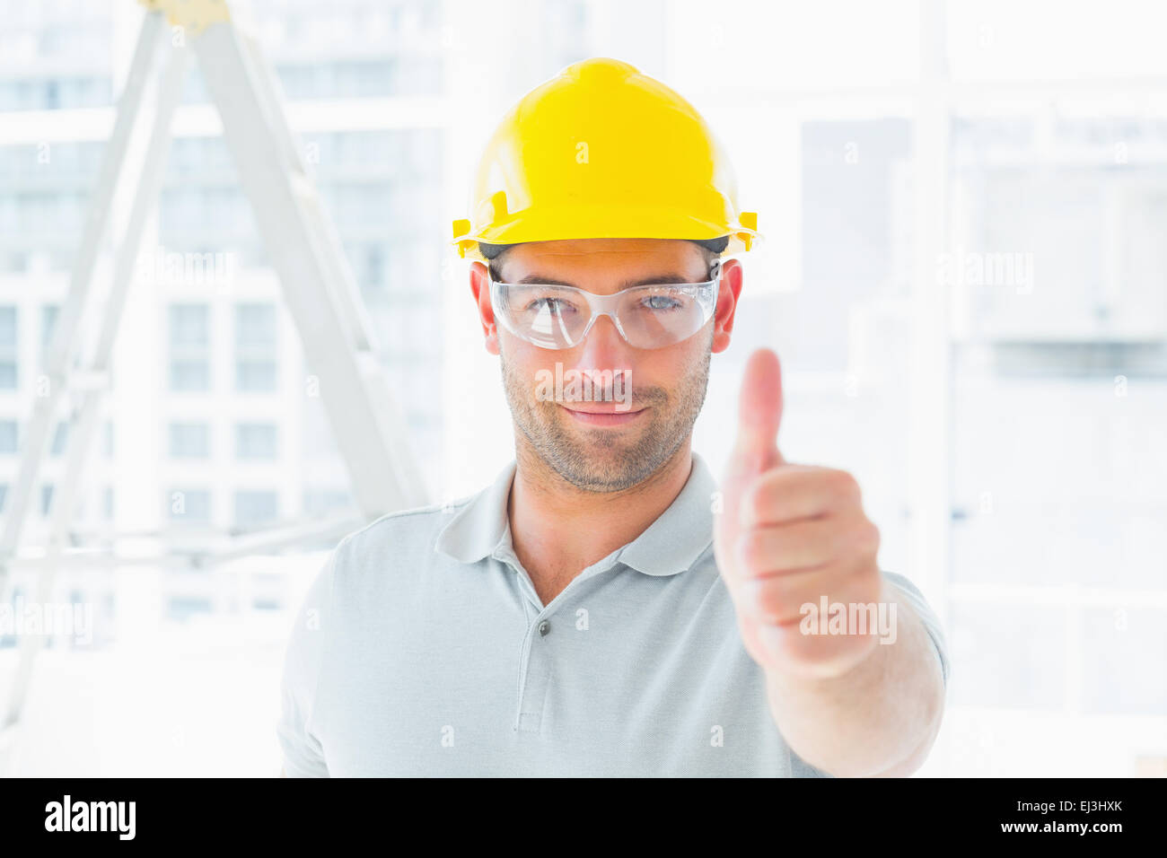 Manual worker gesturing thumbs up at site Stock Photo - Alamy