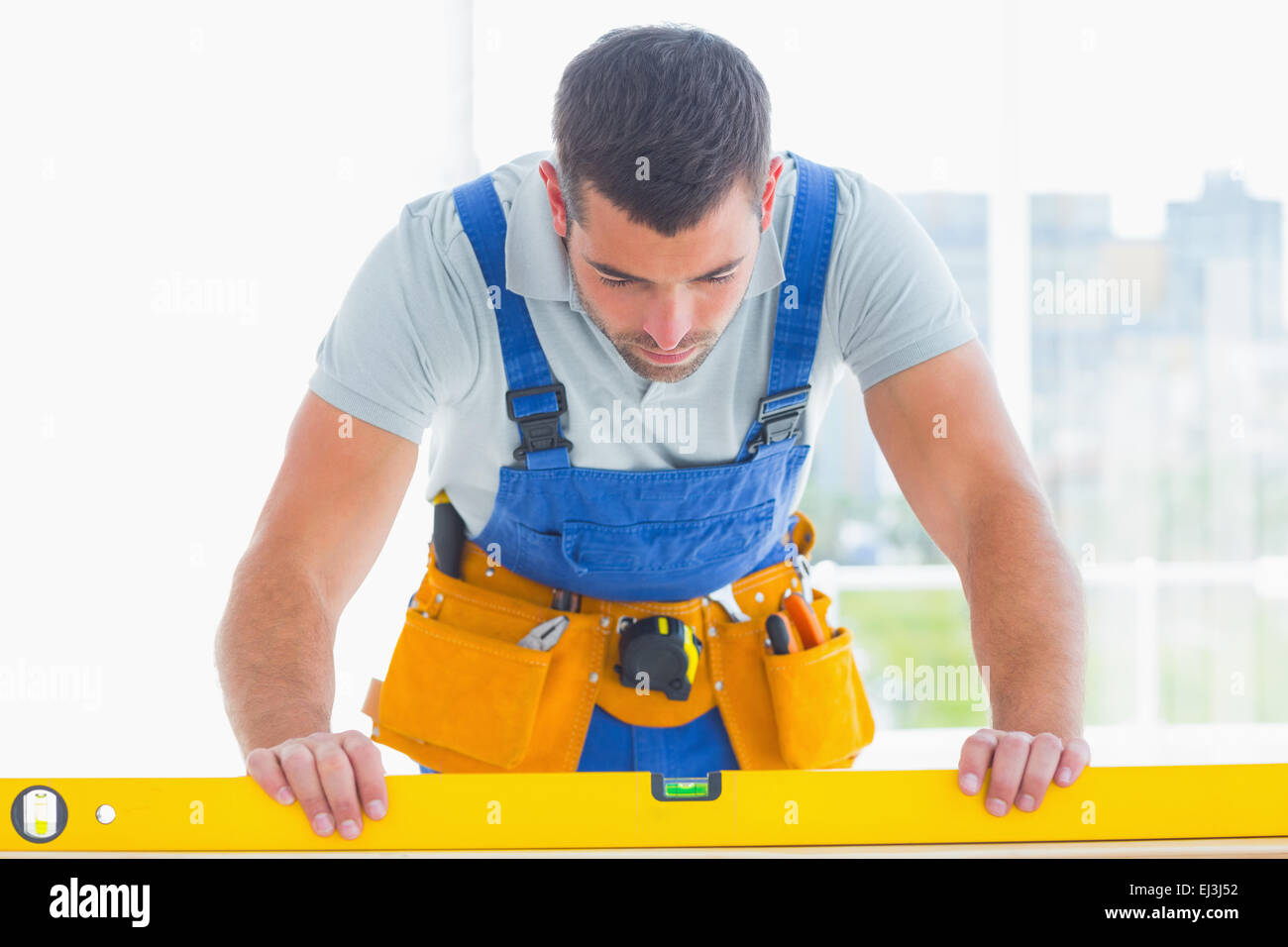 Carpenter using spirit level in office Stock Photo - Alamy