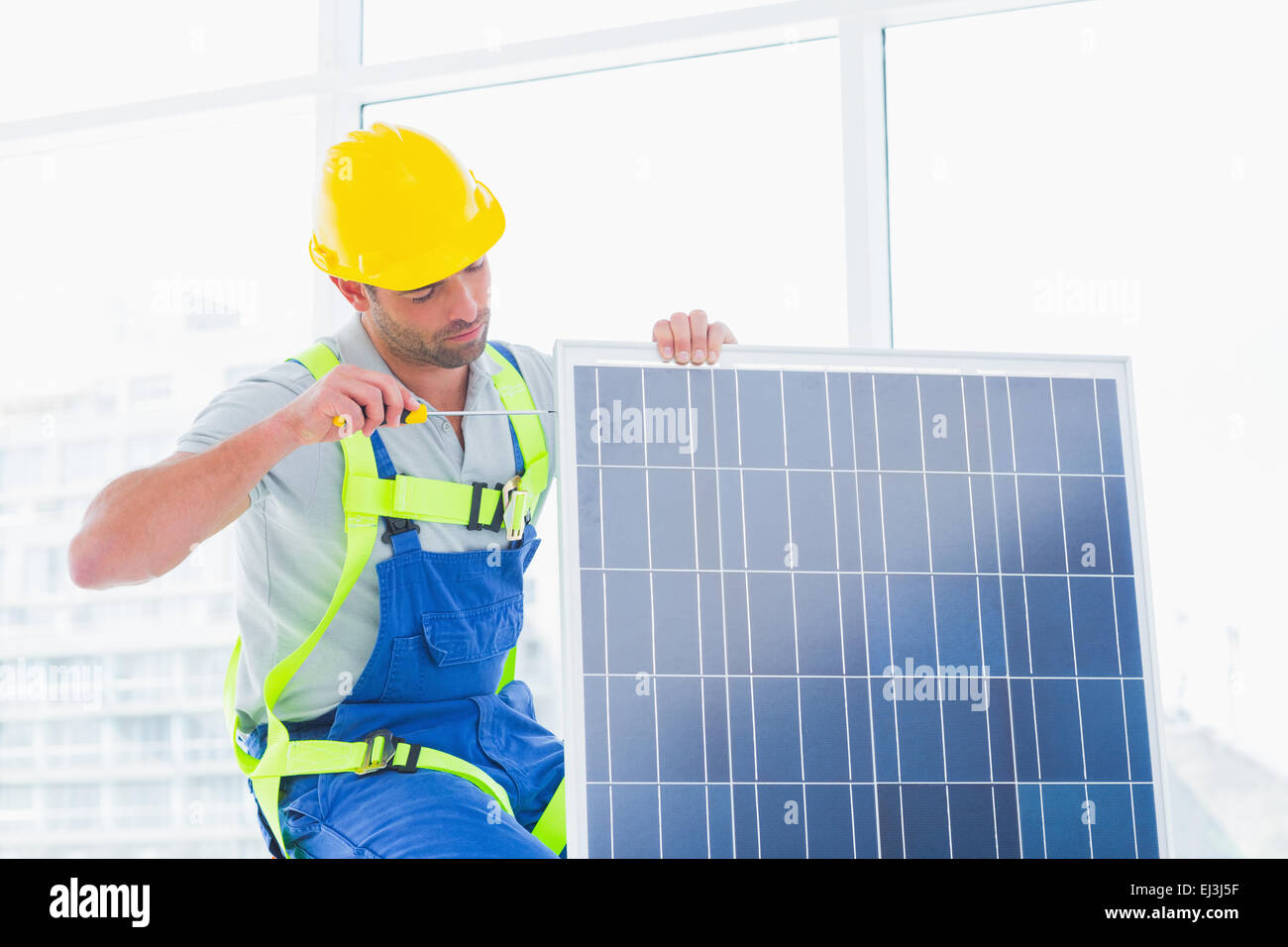 Worker tightening solar panel in office Stock Photo - Alamy