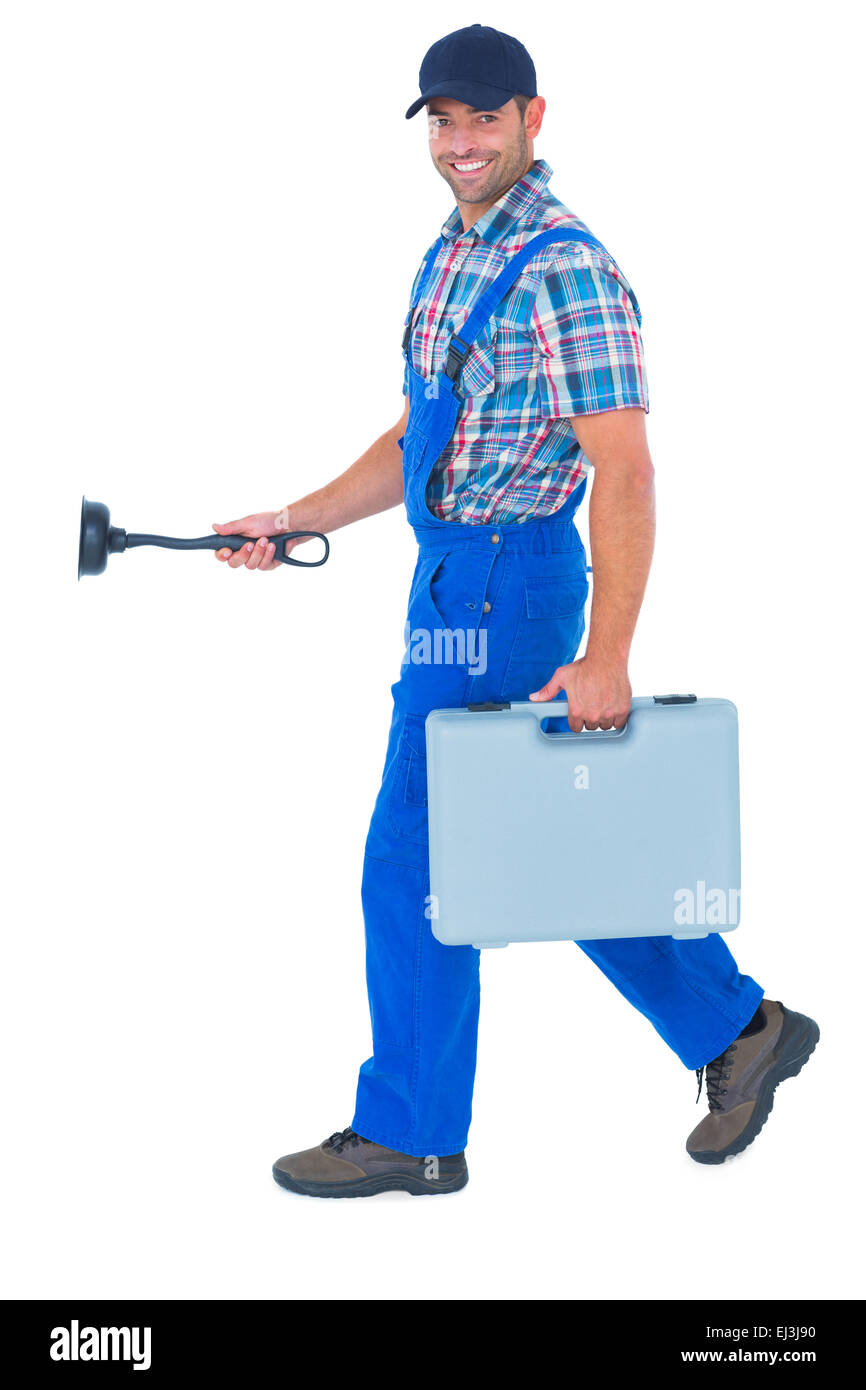 Happy plumber with plunger and toolbox walking on white background ...