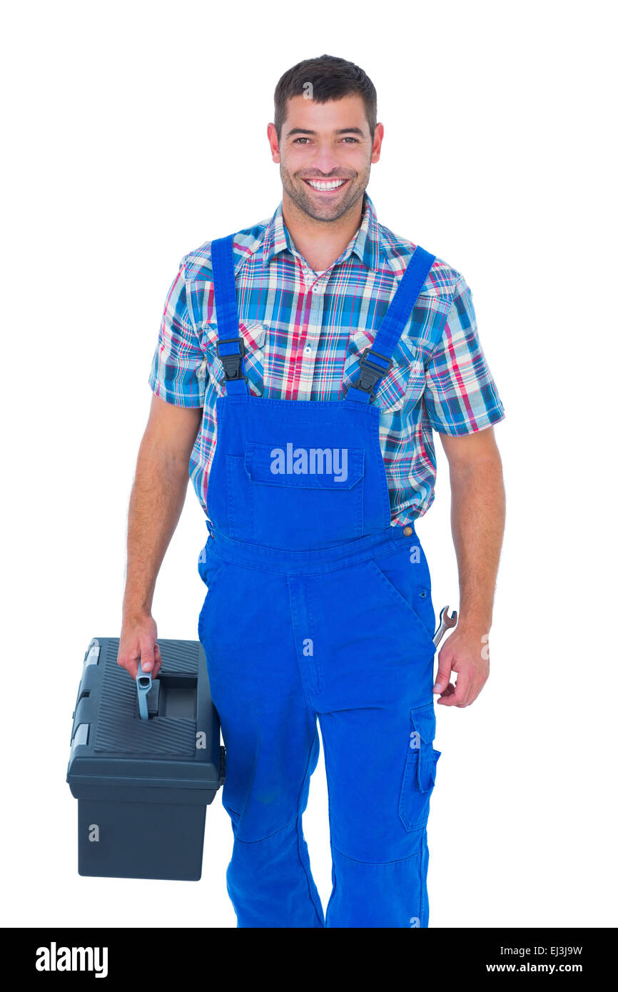 Happy handyman in coveralls carrying toolbox Stock Photo - Alamy