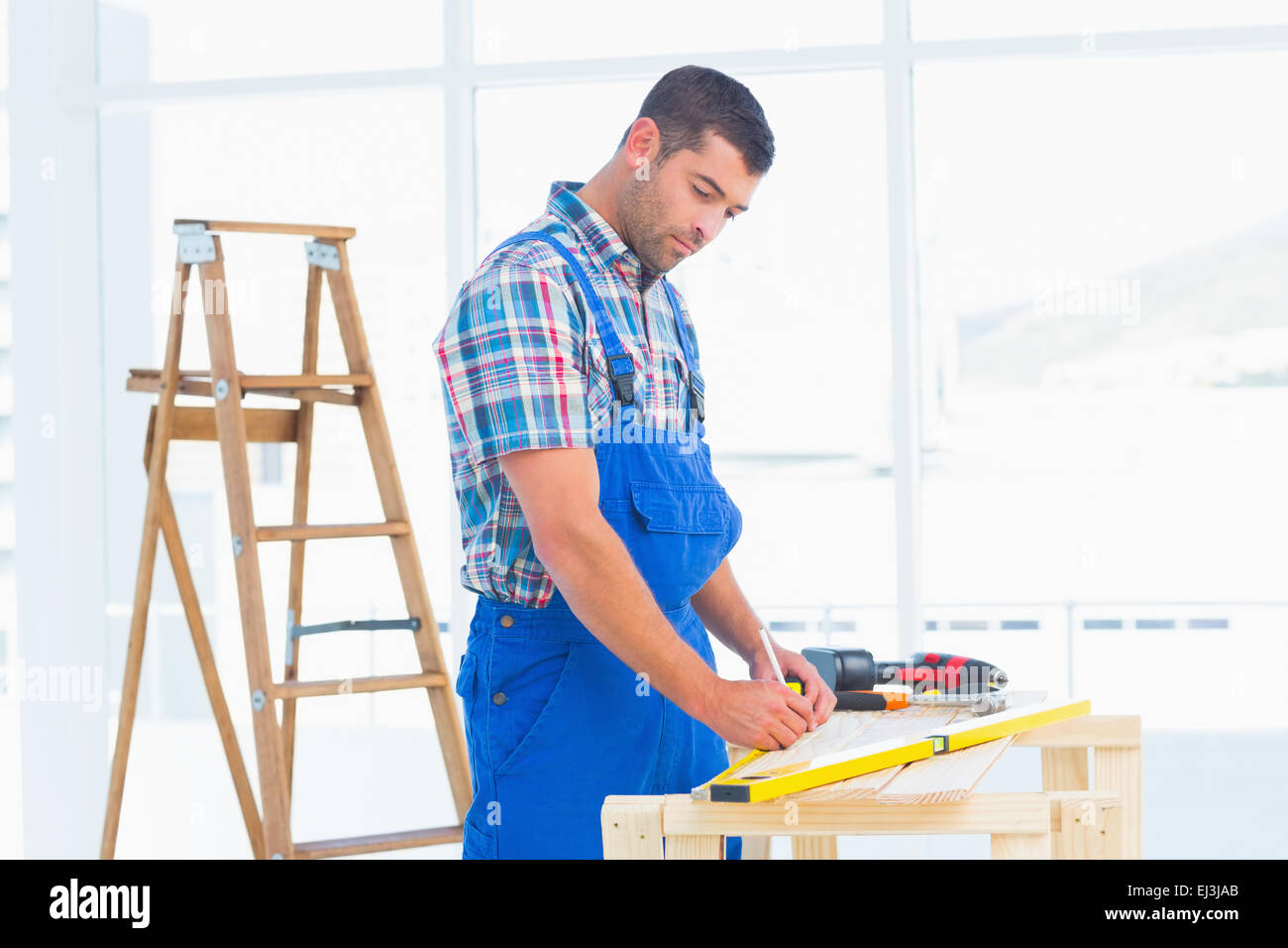 Handyman working at workbench in office Stock Photo - Alamy