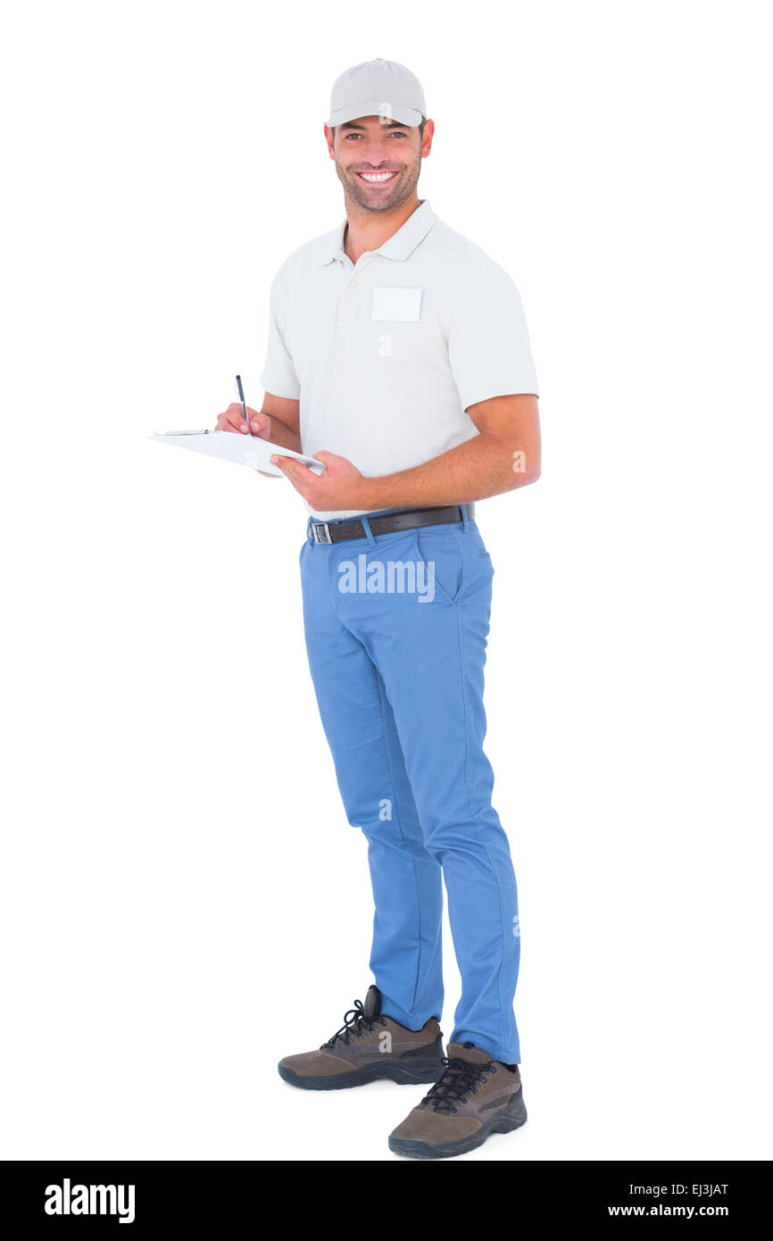 Confident male supervisor writing on clipboard over white background ...