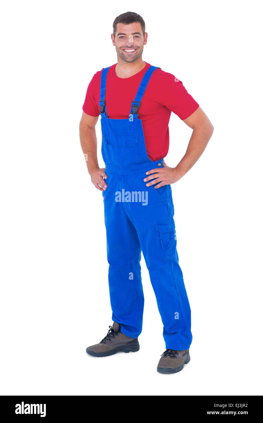 Happy handyman in overalls with hands on hip Stock Photo - Alamy
