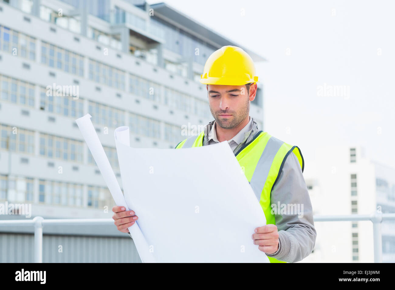 Architect reading blueprint outside building Stock Photo - Alamy