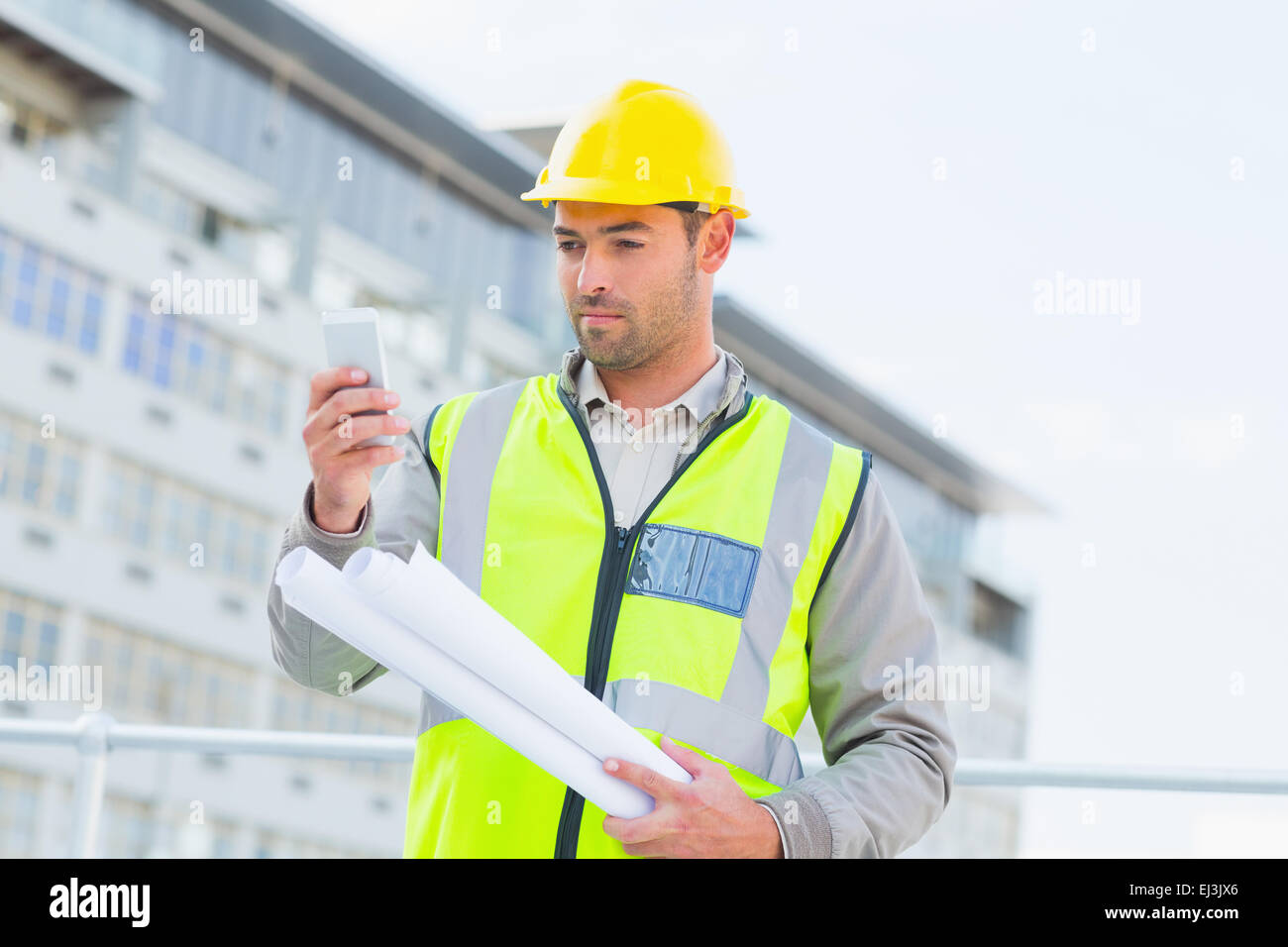 Architect using smartphone against building Stock Photo - Alamy