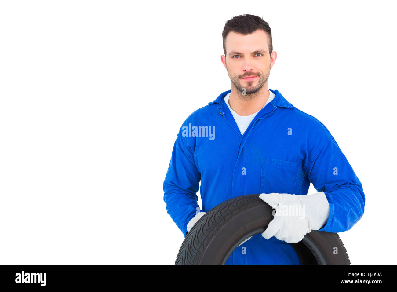 Smiling male mechanic holding tire Stock Photo - Alamy