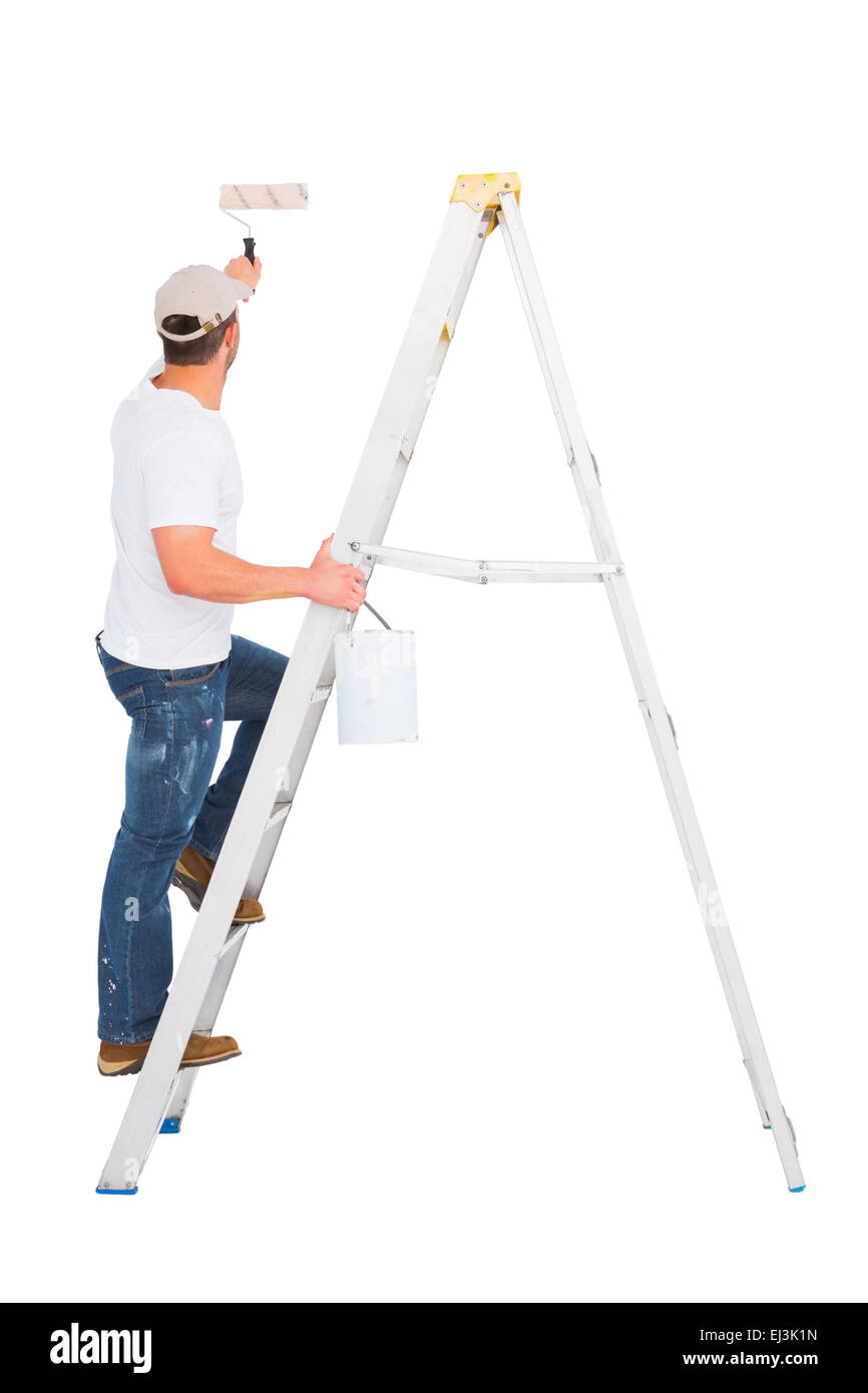 Handyman climbing ladder while using paint roller Stock Photo - Alamy