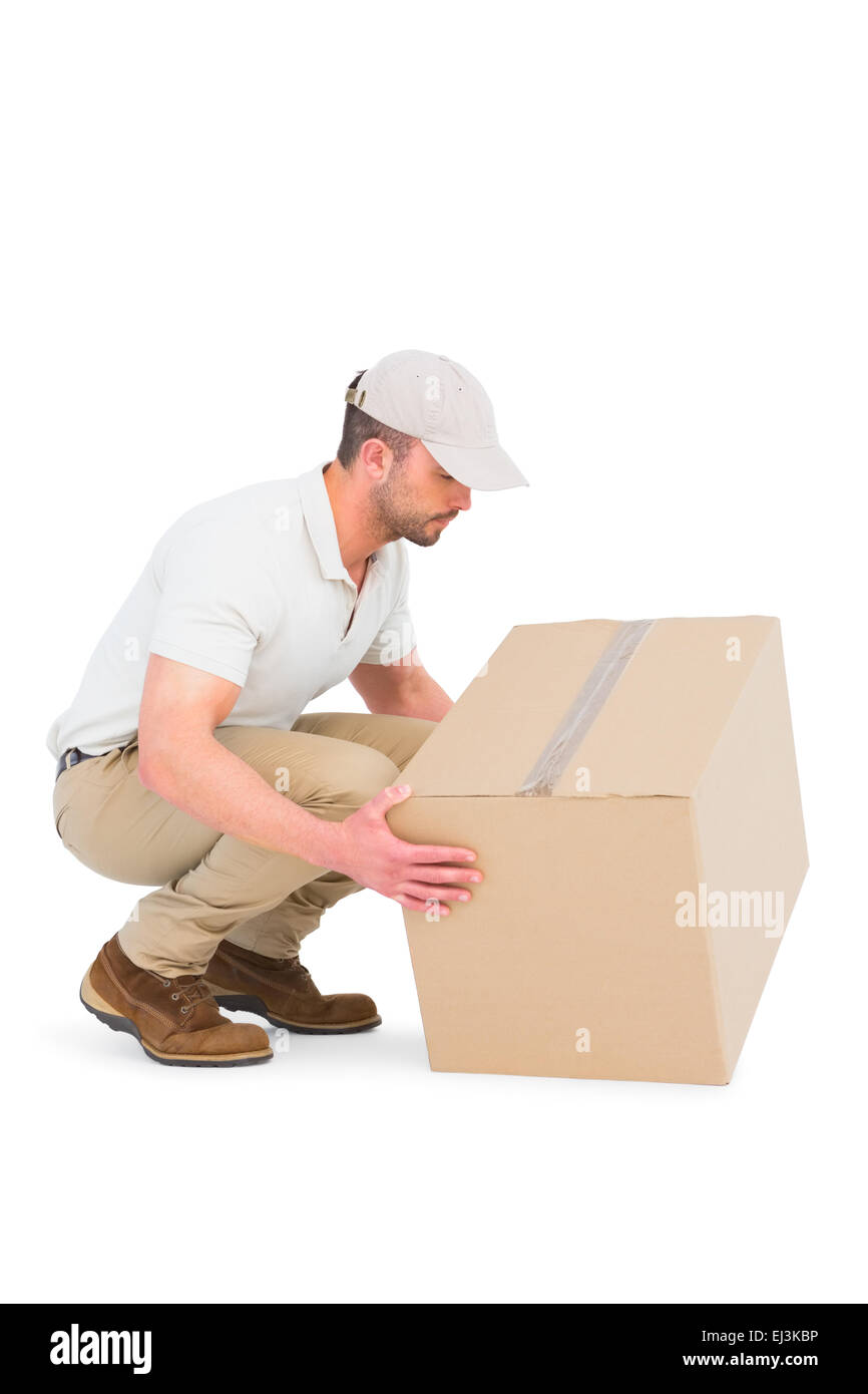 Delivery man crouching while picking cardboard box Stock Photo - Alamy
