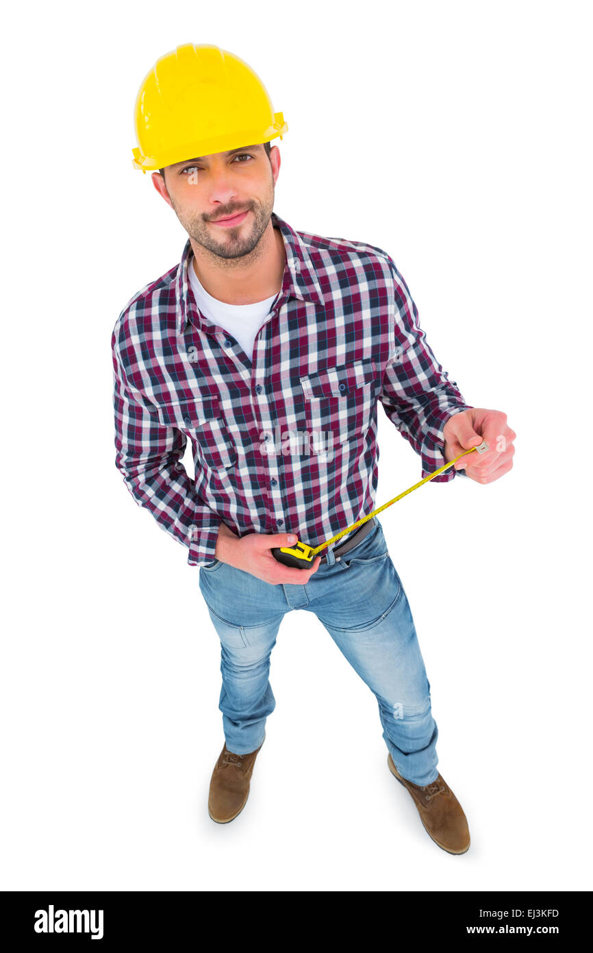 Smiling handyman holding tape measure Stock Photo - Alamy
