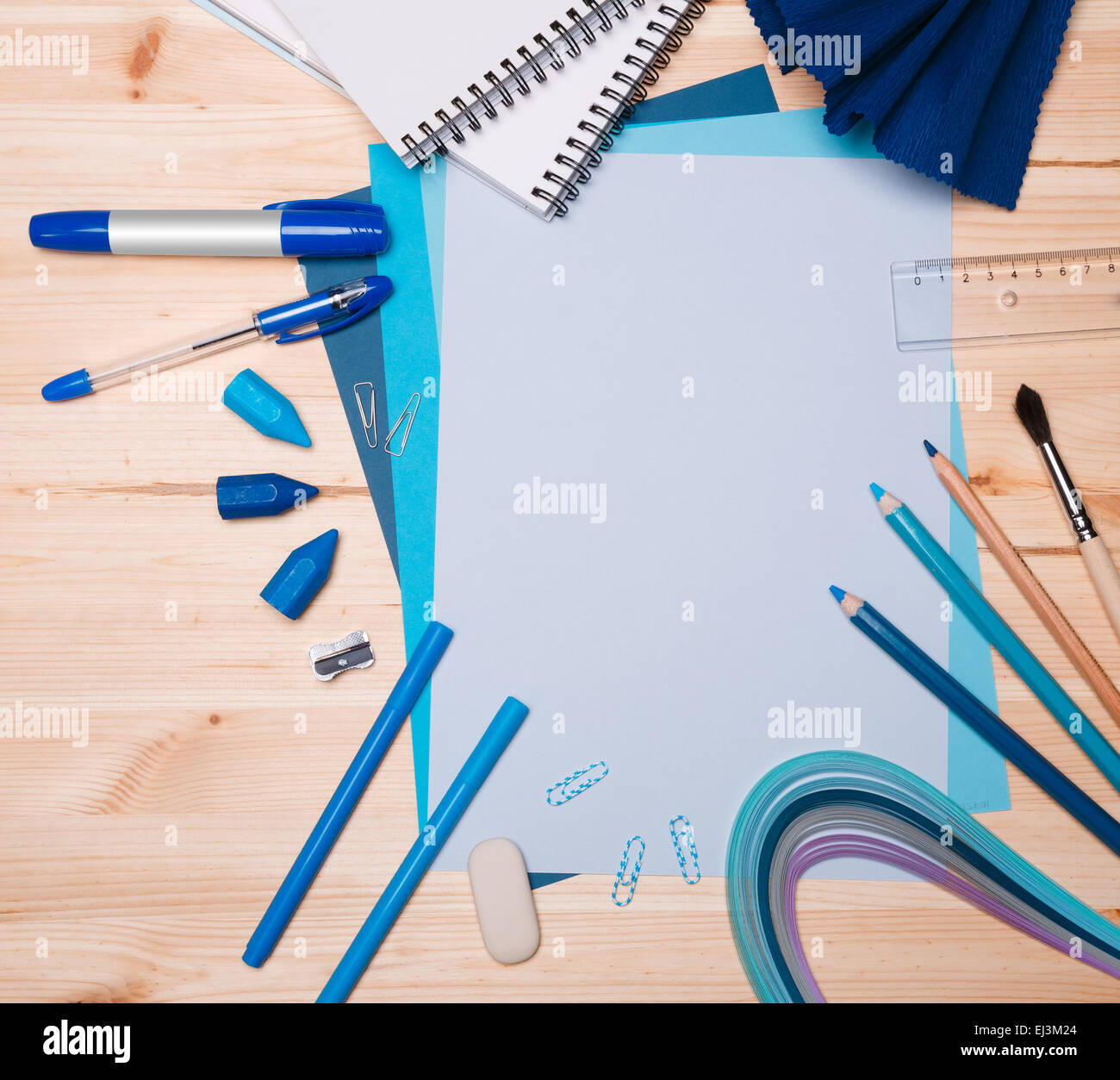 various drawing tools - blue paper and pencils and other lying on a ...