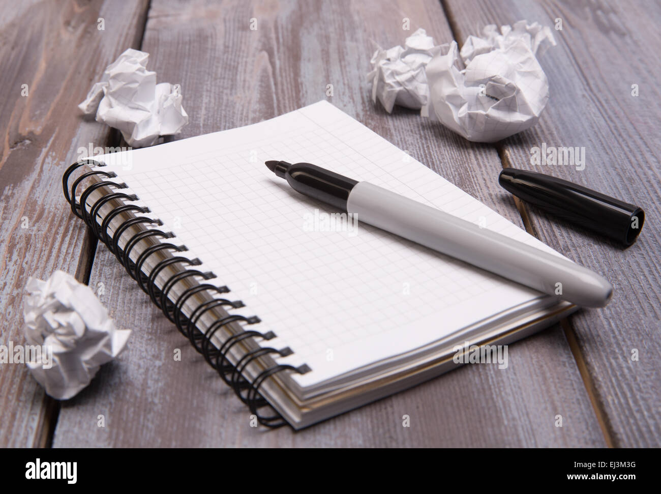 white notebook in a cage with question mark and black marker and ...