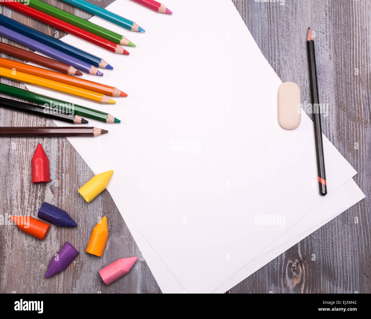 many colorful pencils and others drawing tools on a clear white paper ...