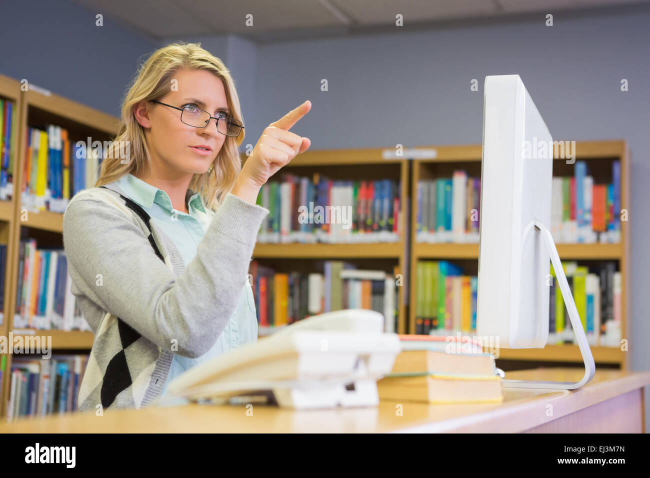 Young woman in library pointing hi-res stock photography and images - Alamy