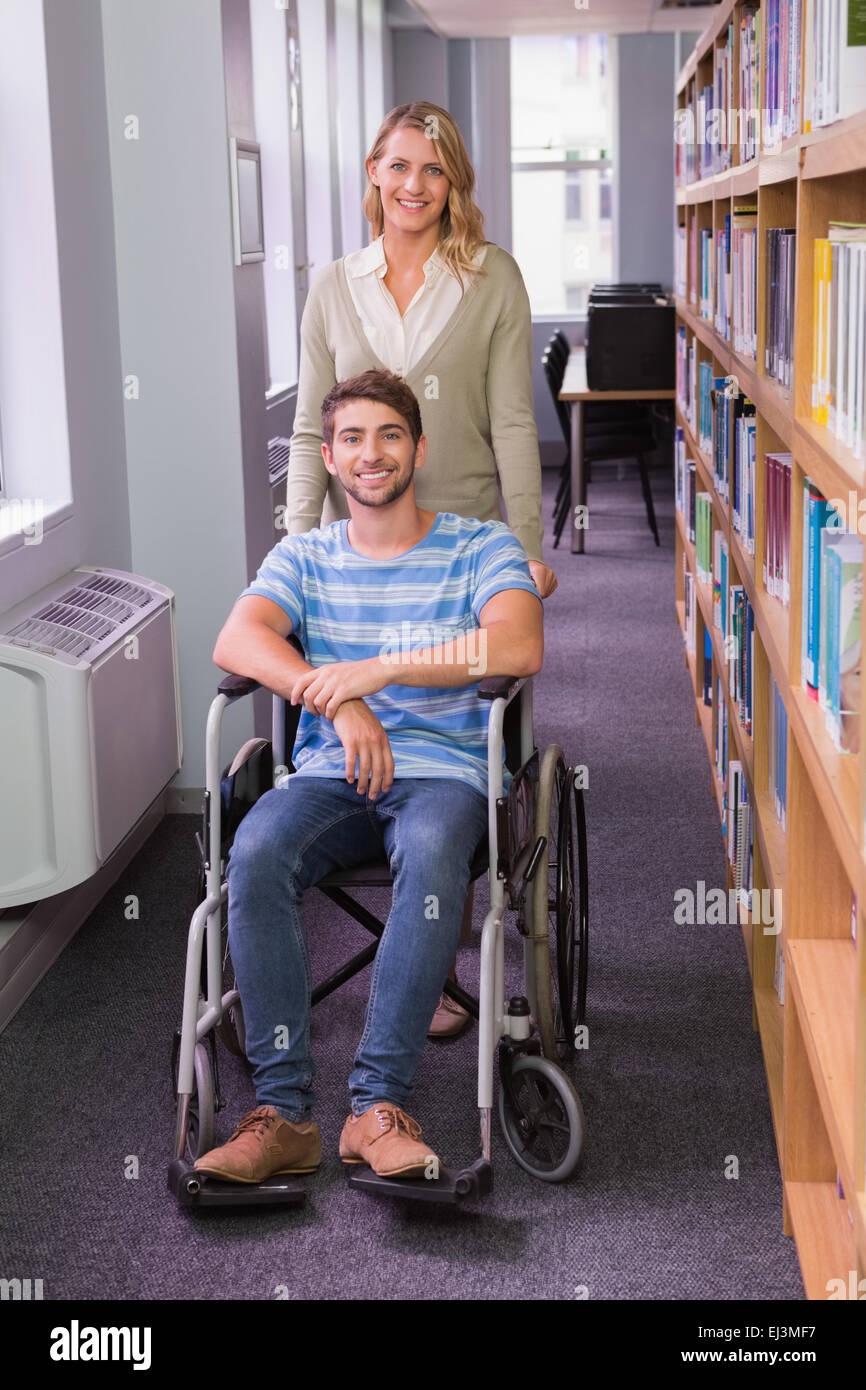 Smiling disabled student with classmate in library Stock Photo - Alamy