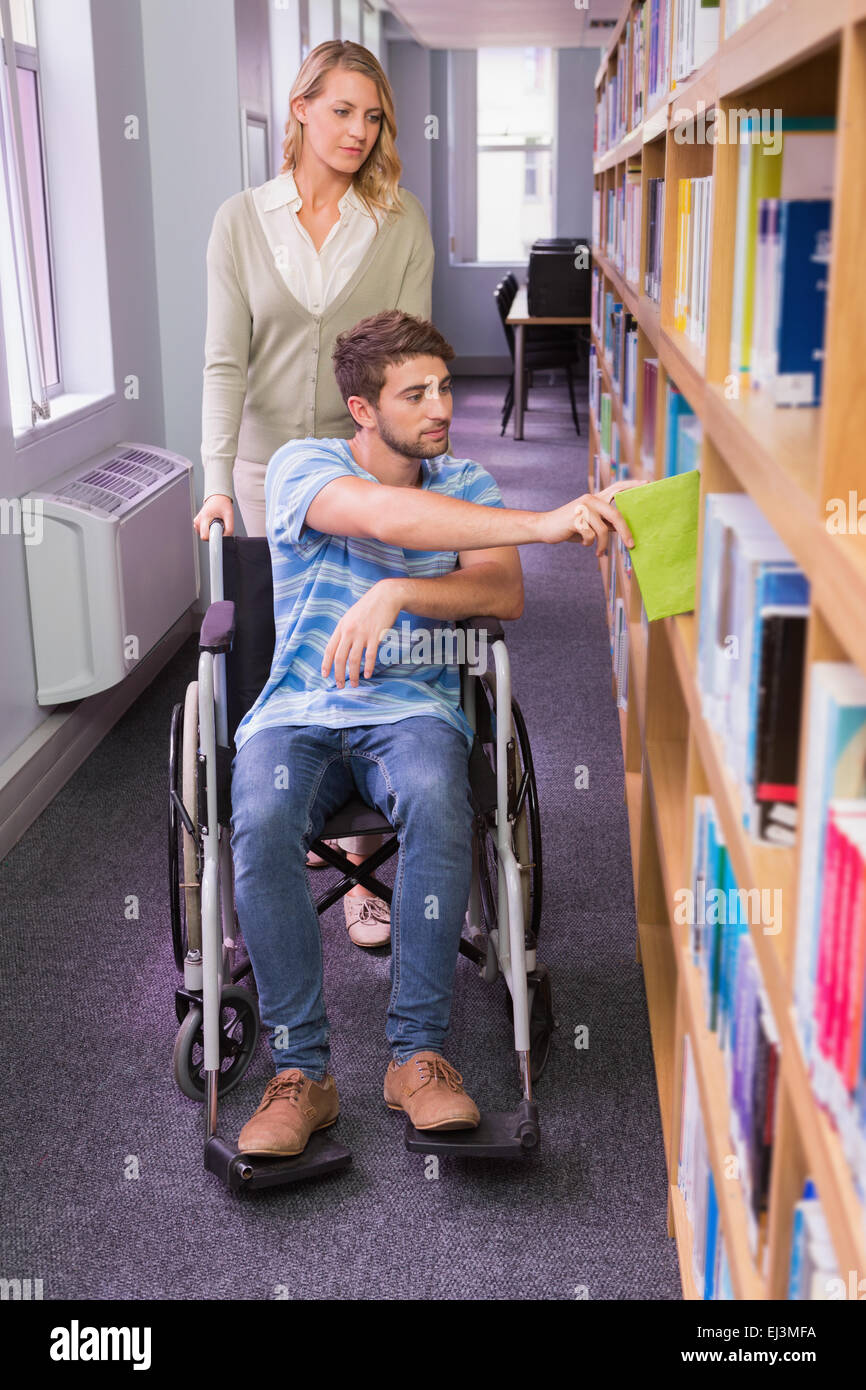 Smiling disabled student with classmate in library Stock Photo - Alamy