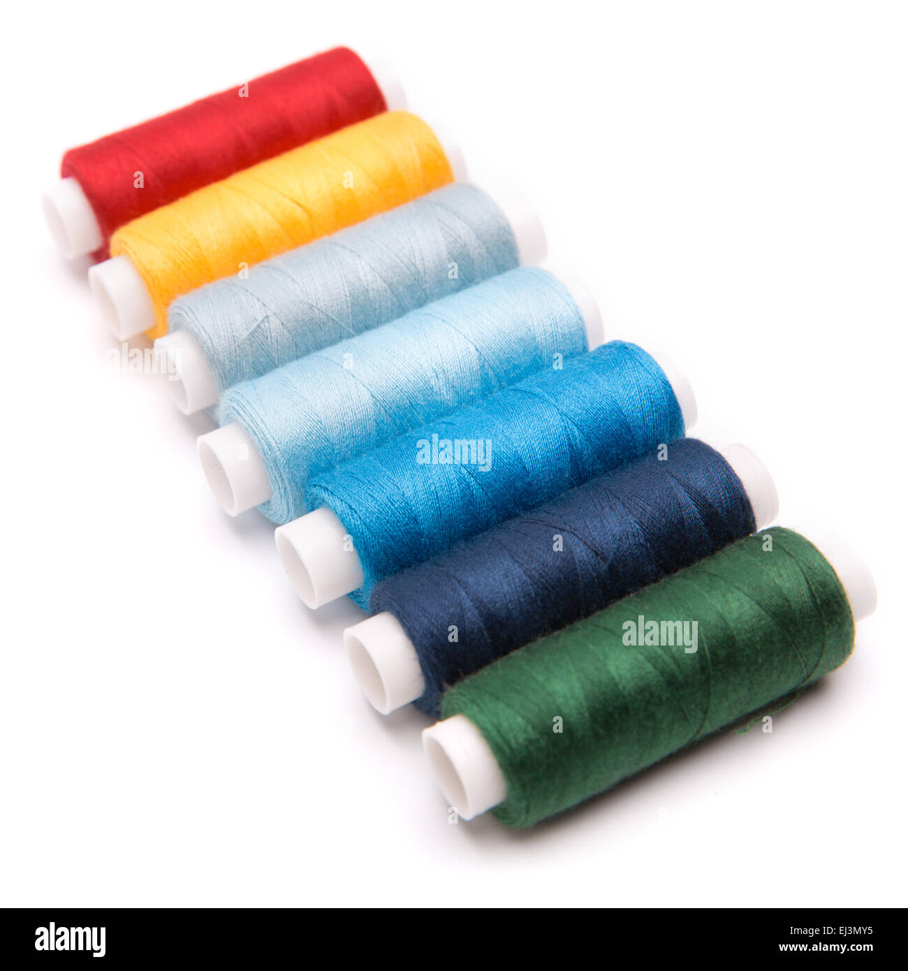 different rainbow colored coils with threads on a white background ...