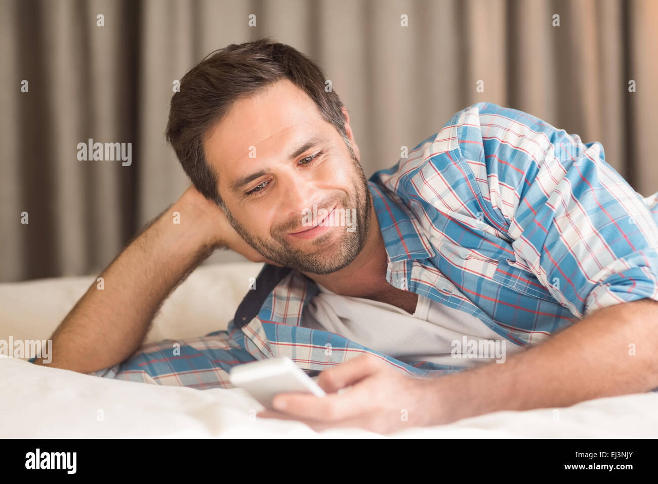 Handsome man relaxing on his bed Stock Photo - Alamy