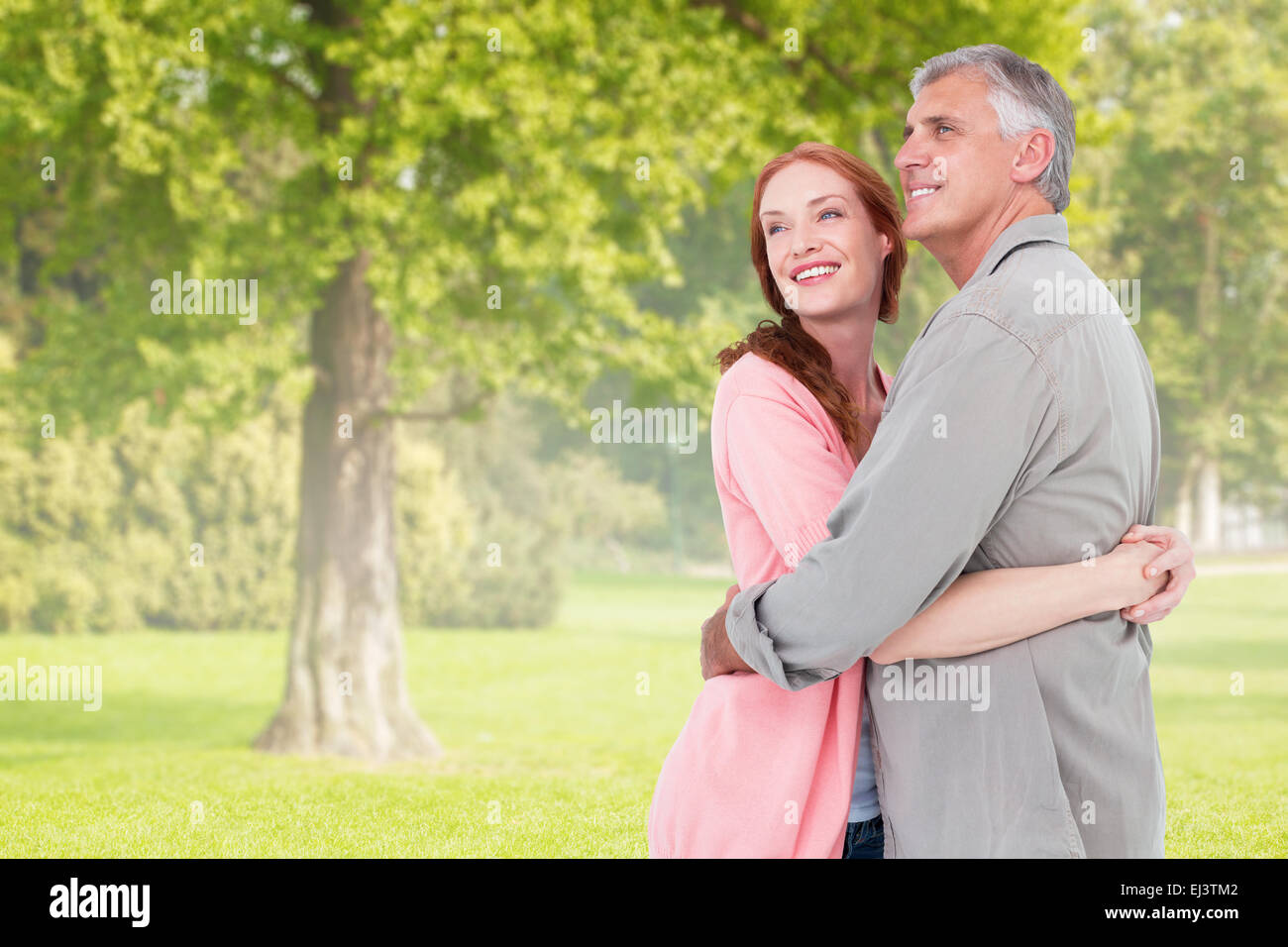 Composite image of casual couple hugging and smiling Stock Photo - Alamy