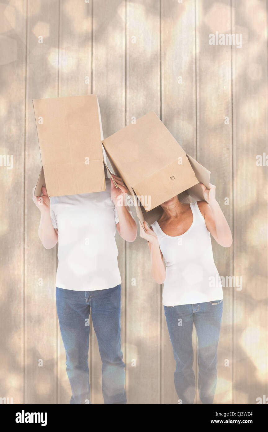 Composite image of mature couple wearing boxes over their heads Stock ...
