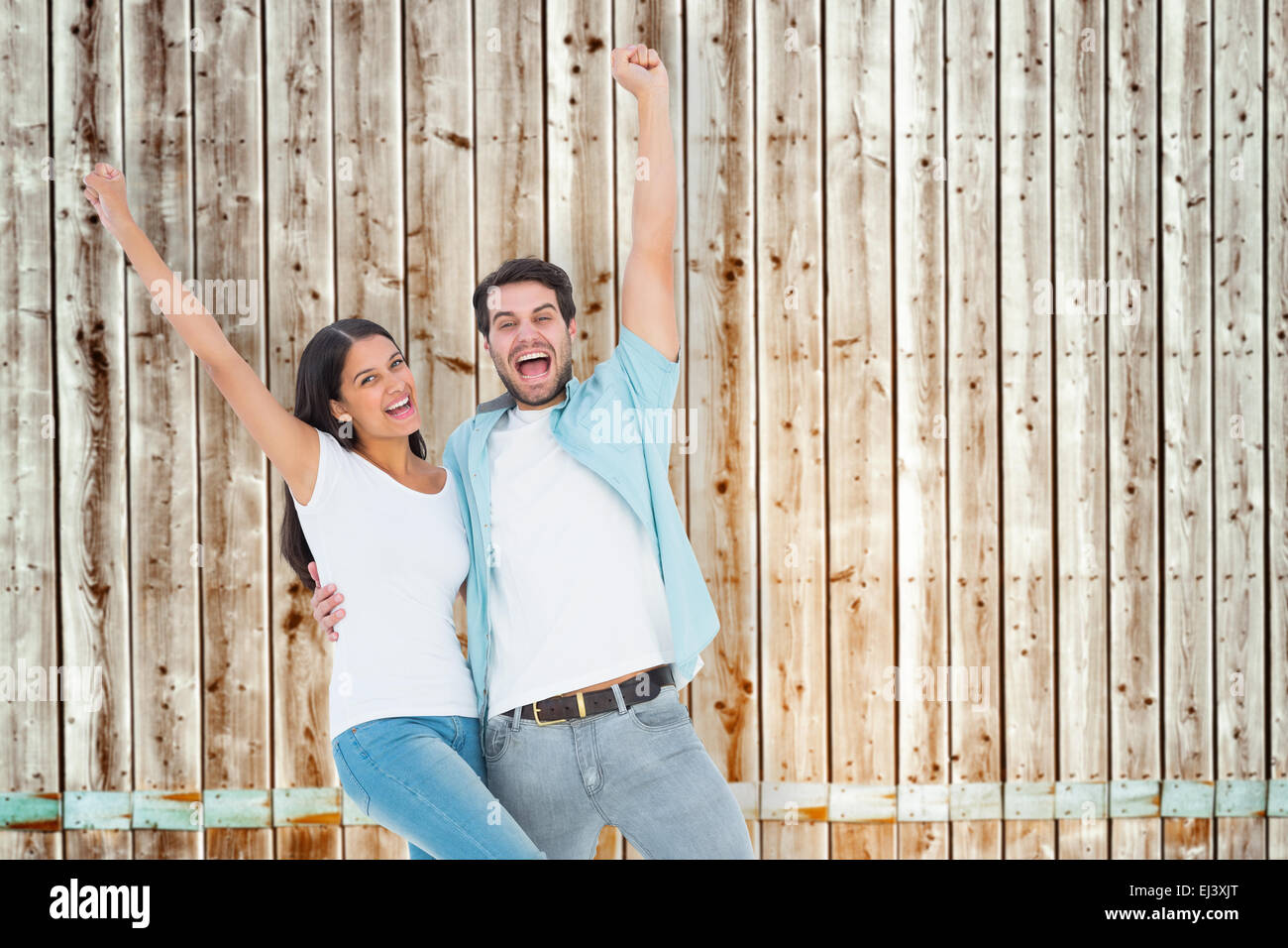 Composite image of happy casual couple cheering together Stock Photo ...