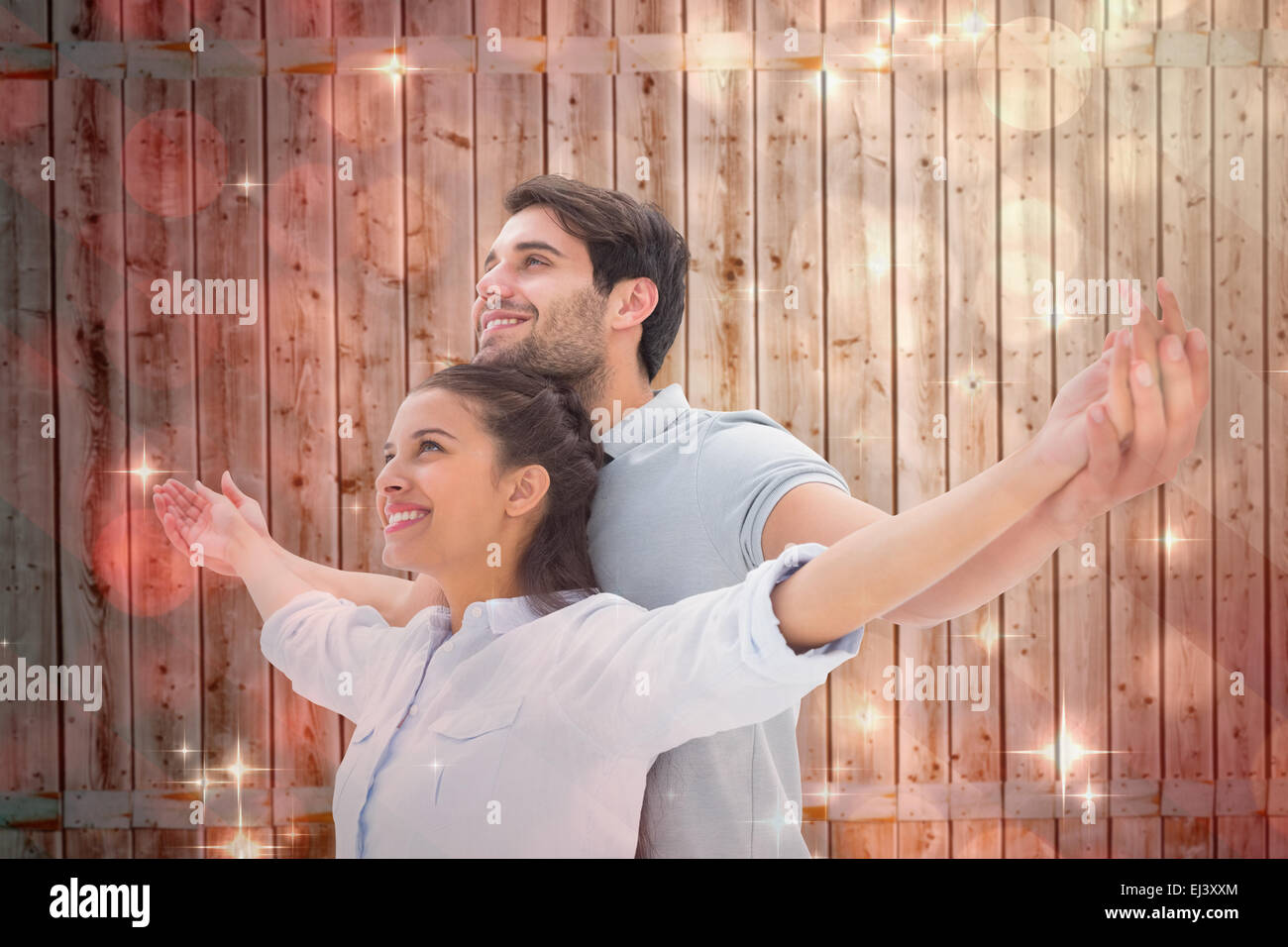 Composite image of cute couple standing with arms out Stock Photo - Alamy