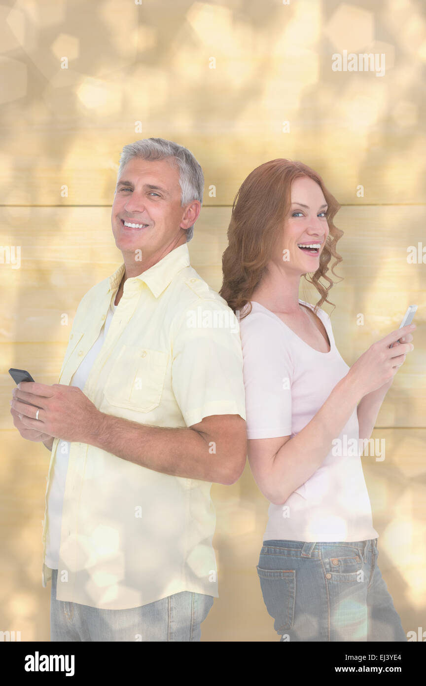 Composite image of casual couple sending text messages Stock Photo - Alamy