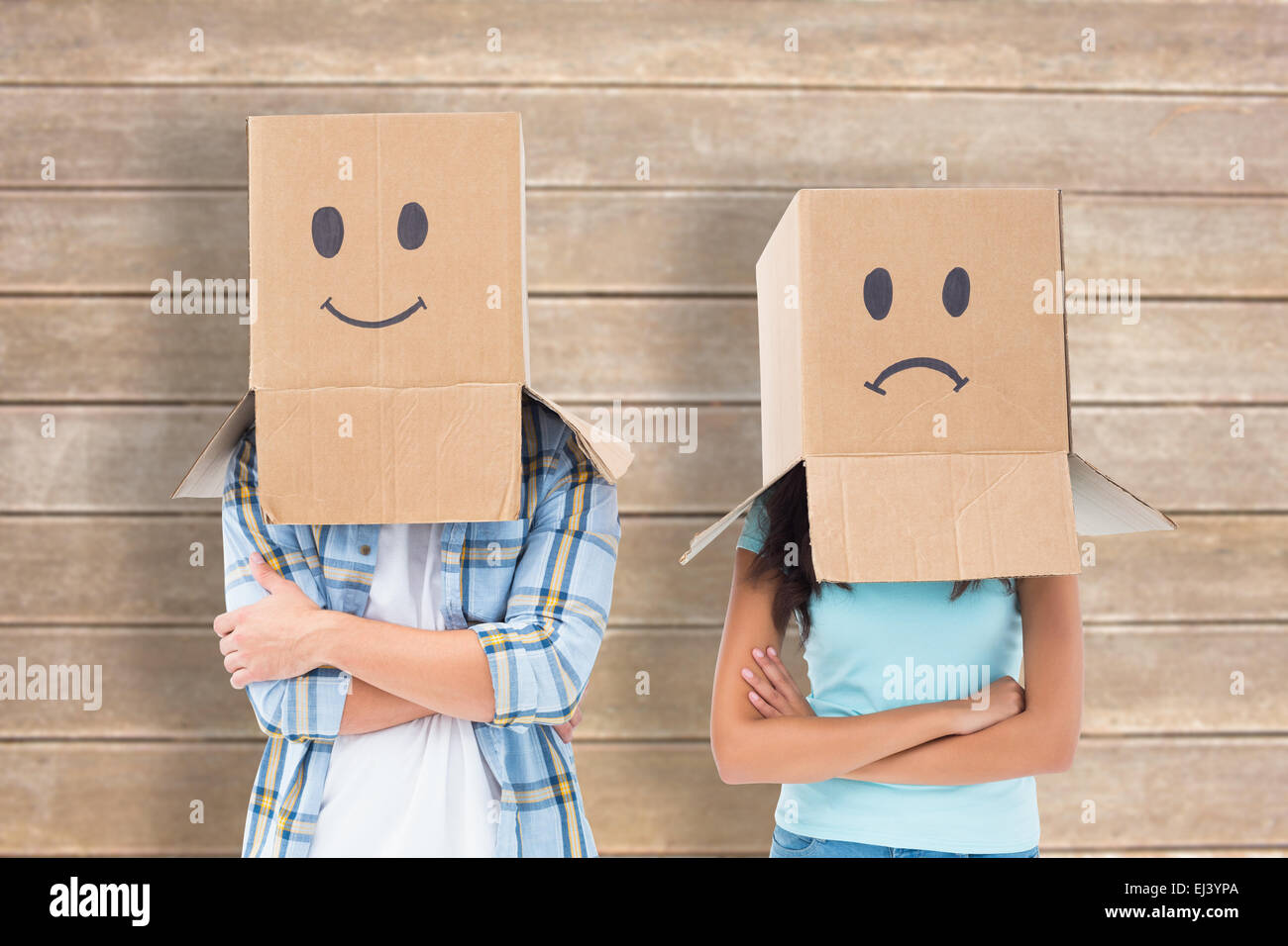 Composite image of young couple wearing sad face boxes over head Stock ...