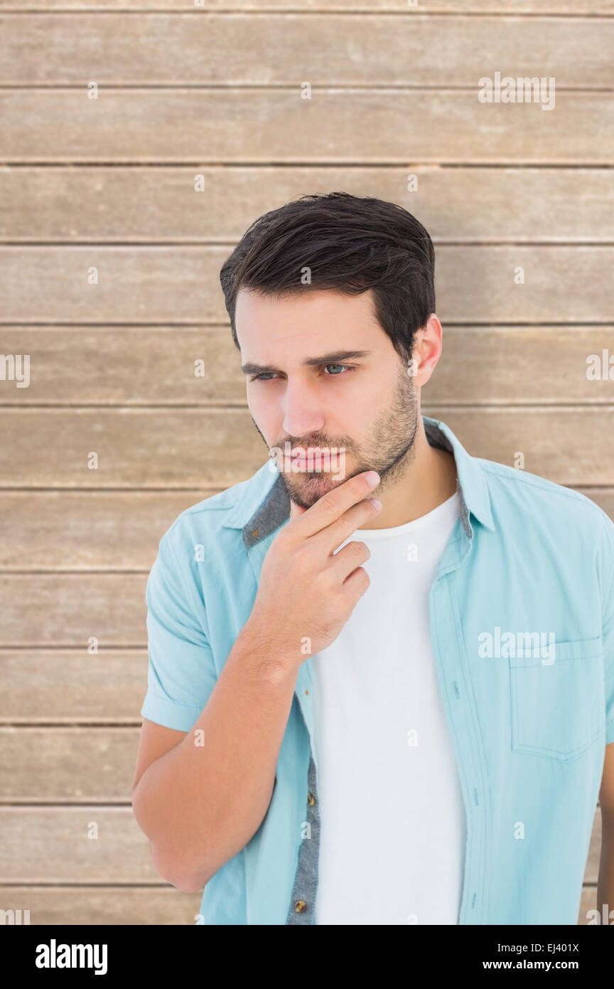 Composite image of happy casual man thinking with hand on chin Stock ...