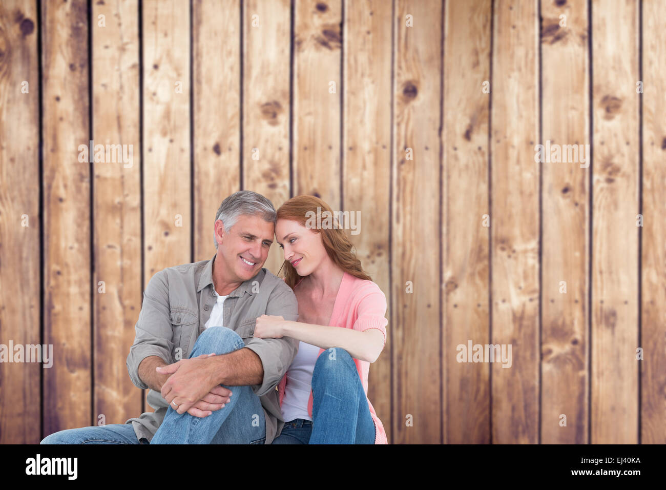Composite image of casual couple sitting and smiling Stock Photo - Alamy