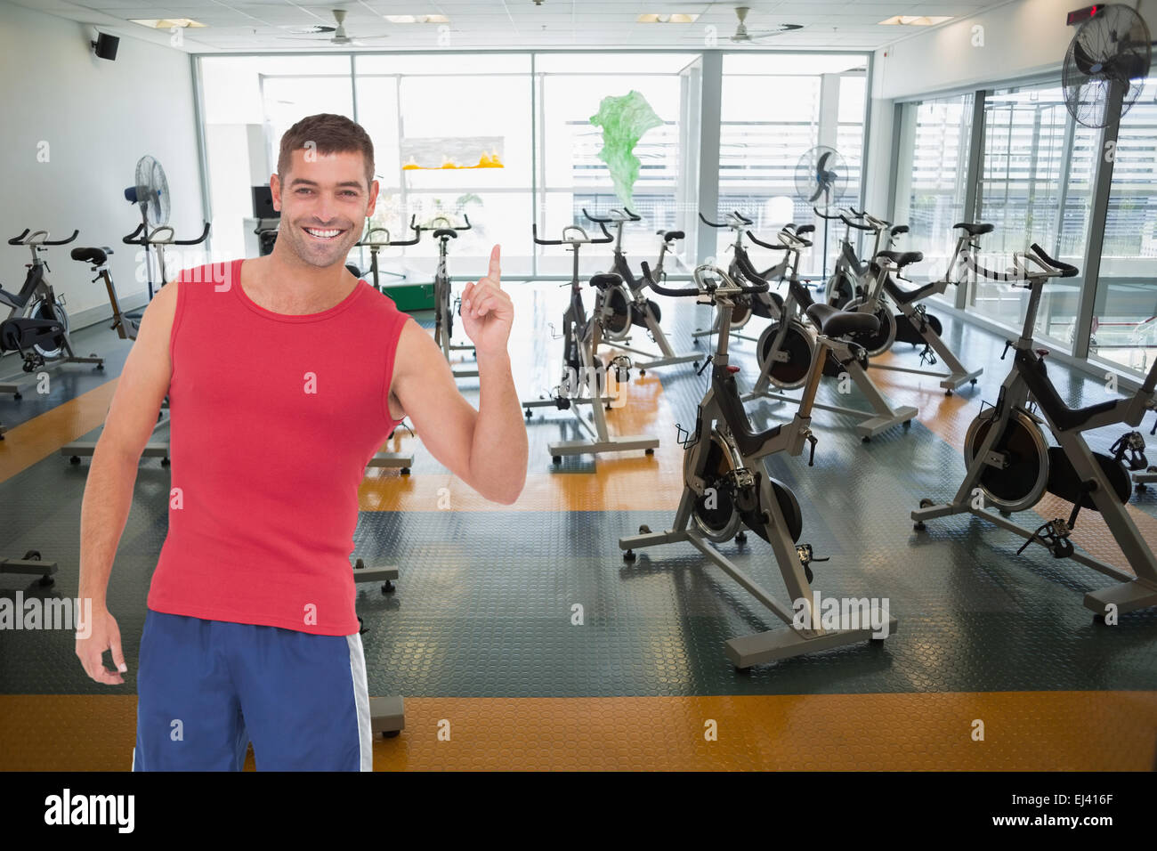 Composite image of fit man smiling and pointing Stock Photo - Alamy