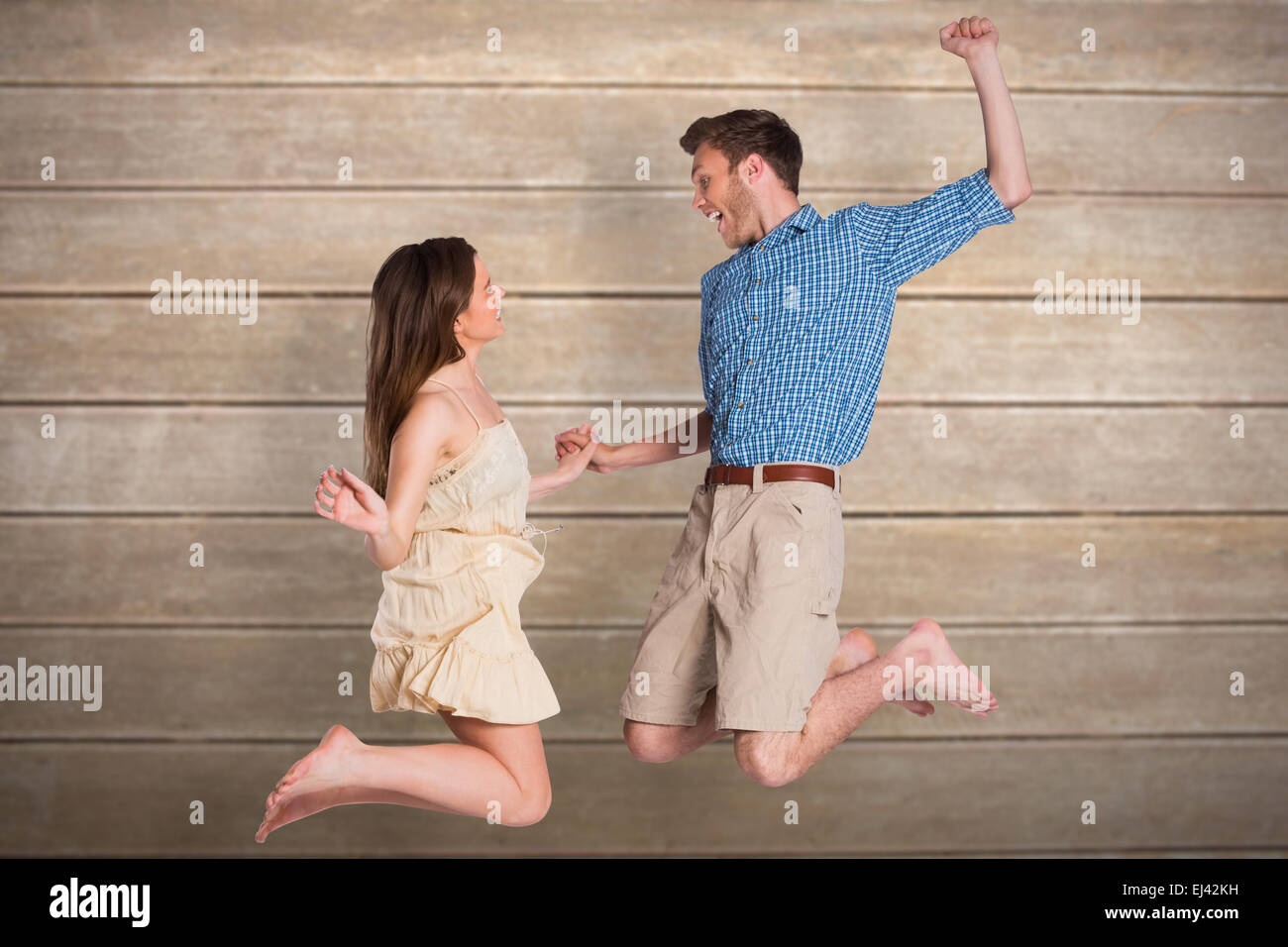 Composite image of cheerful young couple jumping Stock Photo - Alamy