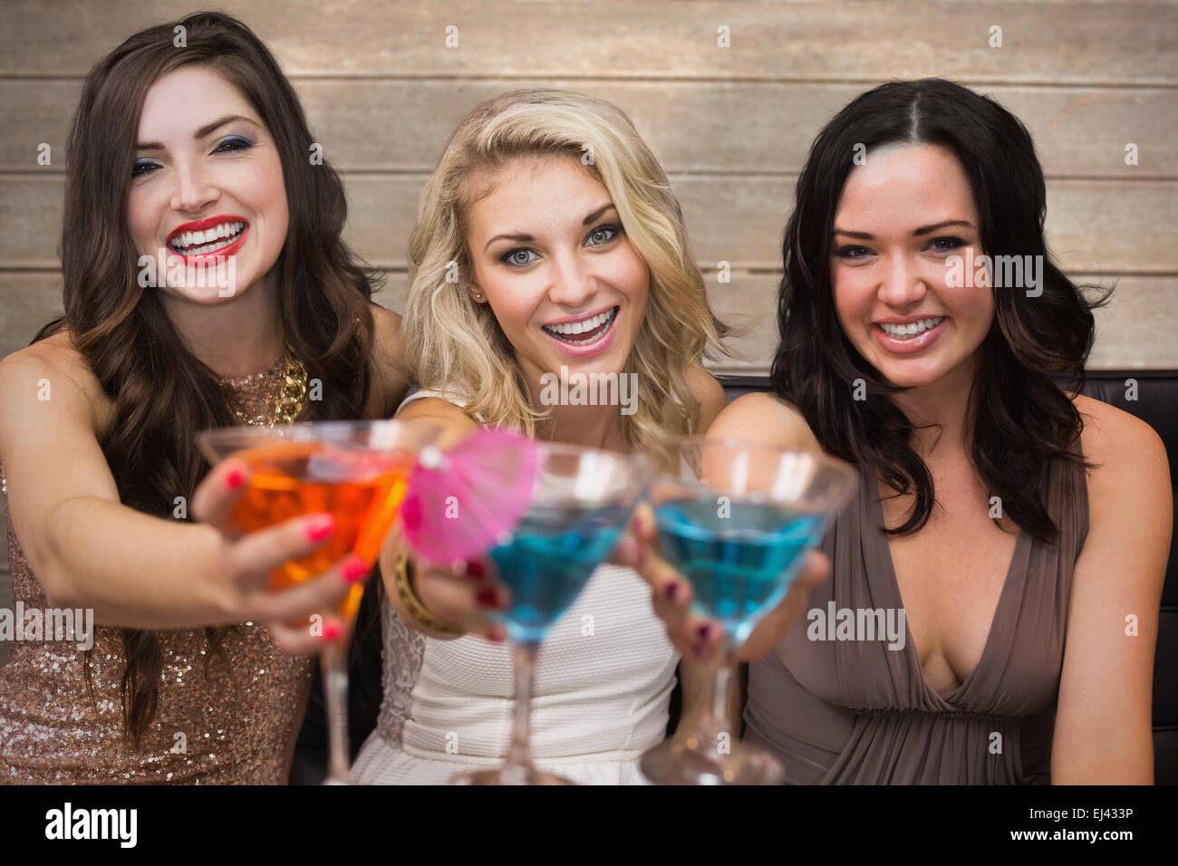 Composite image of pretty friends drinking cocktails together Stock ...