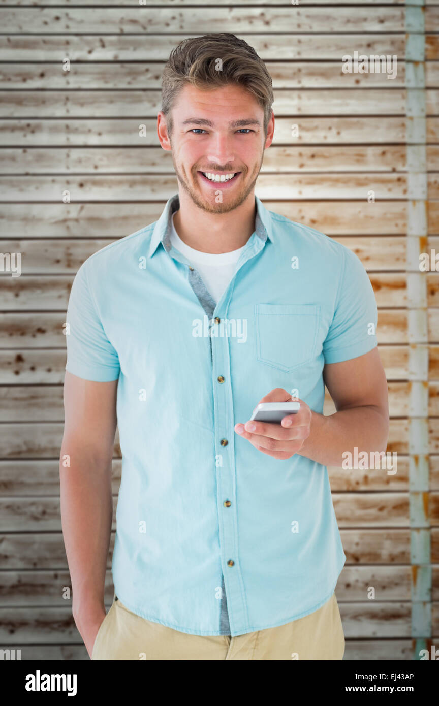 Composite image of handsome young man using his smartphone Stock Photo ...