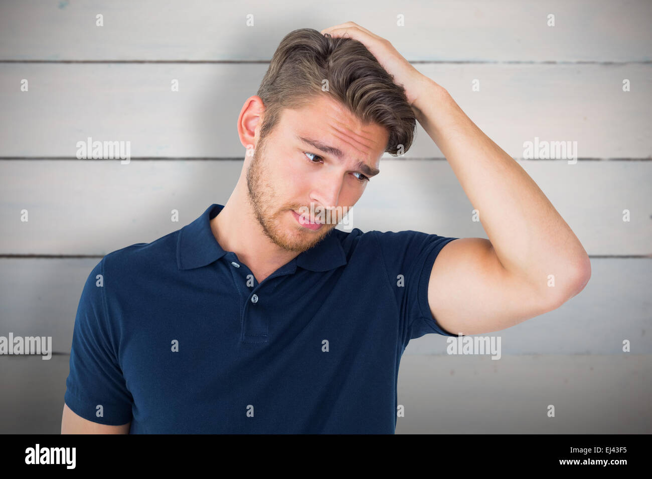 Composite image of handsome young man looking confused Stock Photo - Alamy