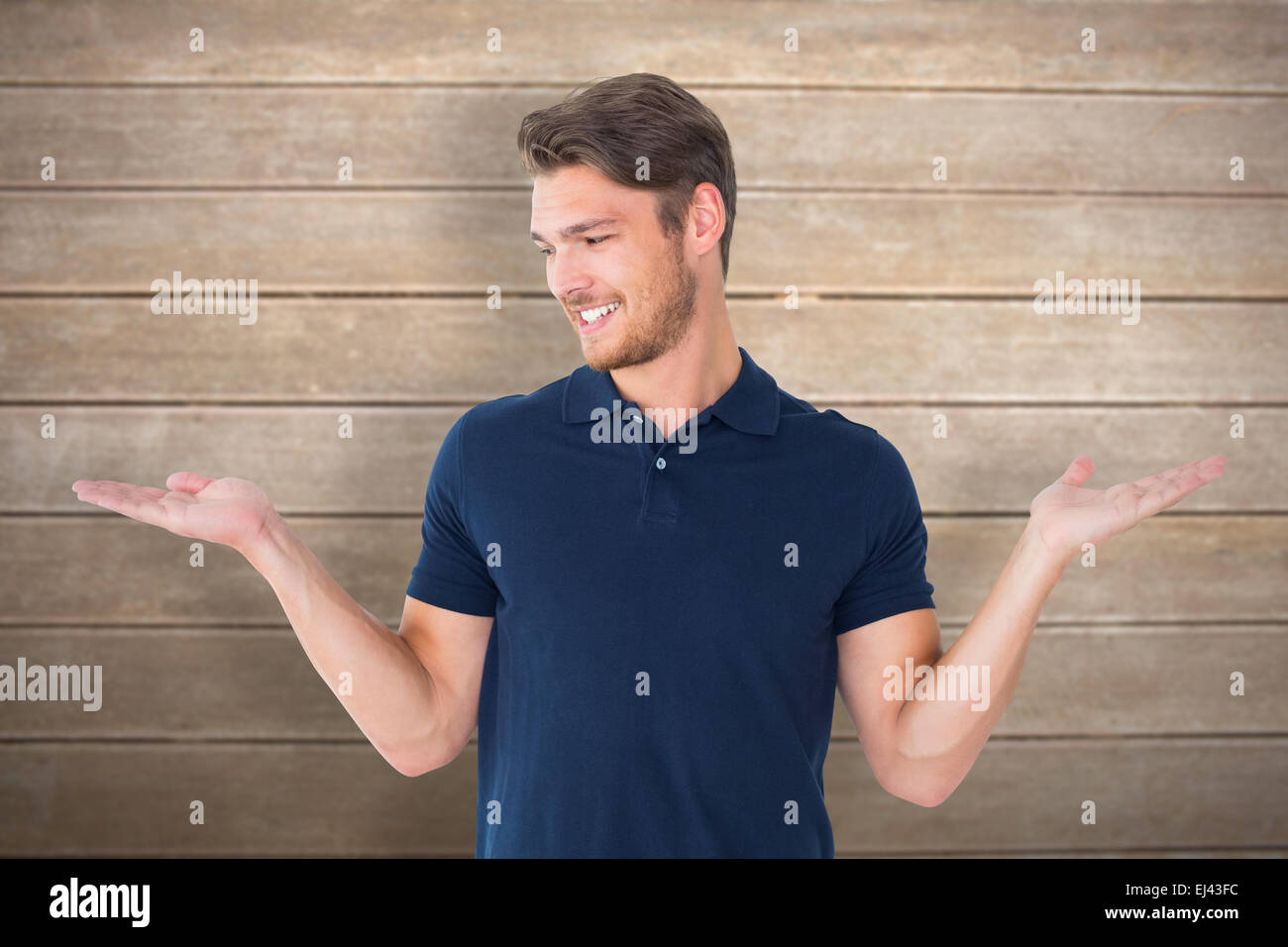 Composite image of handsome young man holding his hands out Stock Photo ...