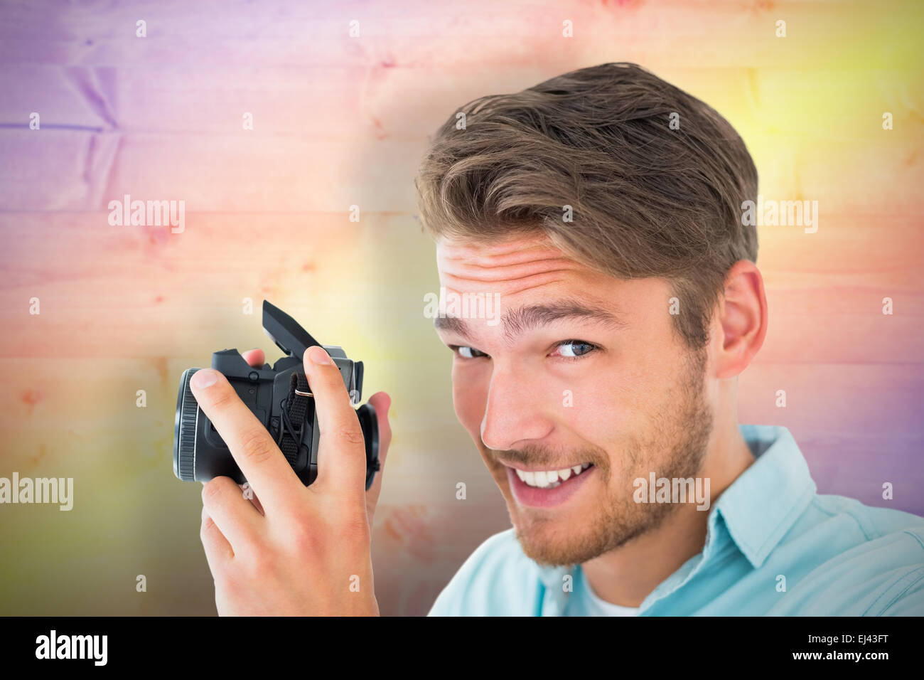 Composite image of handsome young man holding digital camera Stock ...