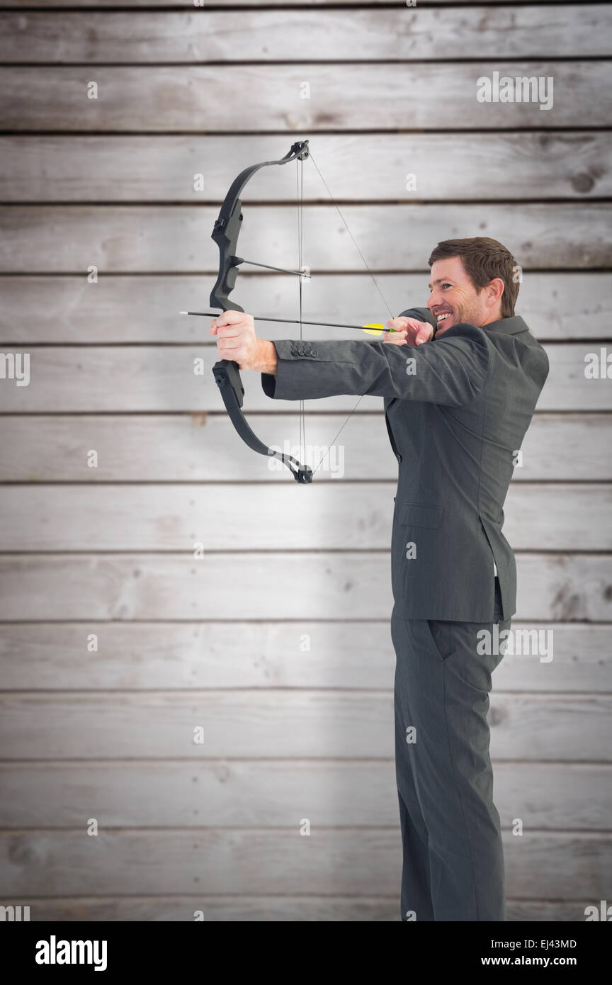 Composite image of businessman shooting a bow and arrow Stock Photo - Alamy