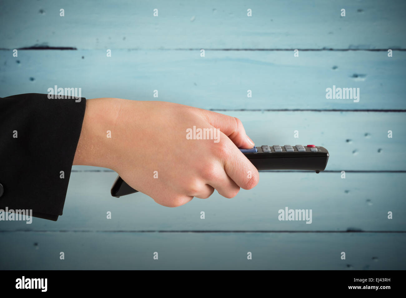 Composite image of hand holding remote control Stock Photo - Alamy