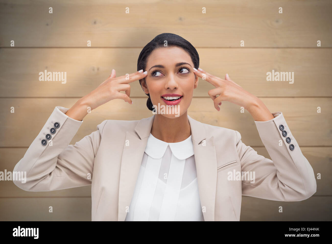 Composite image of confident young businesswoman pointing her head with ...